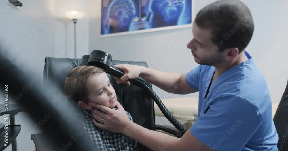 Vidéo Stock Doctor performing TMS exam to child in hospital lab ...