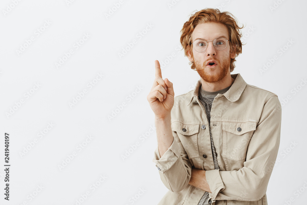 Waist-up shot of creative redhead male genius with wavy hair and beard ...