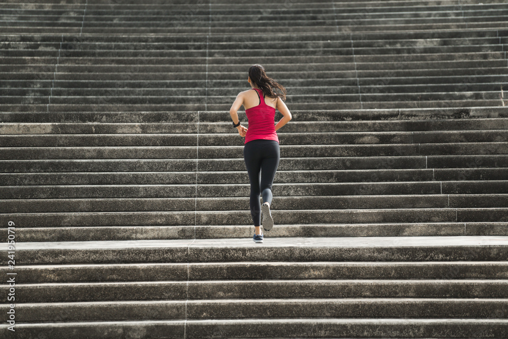 Fitness woman she is running up the stairs. Stock Photo | Adobe Stock