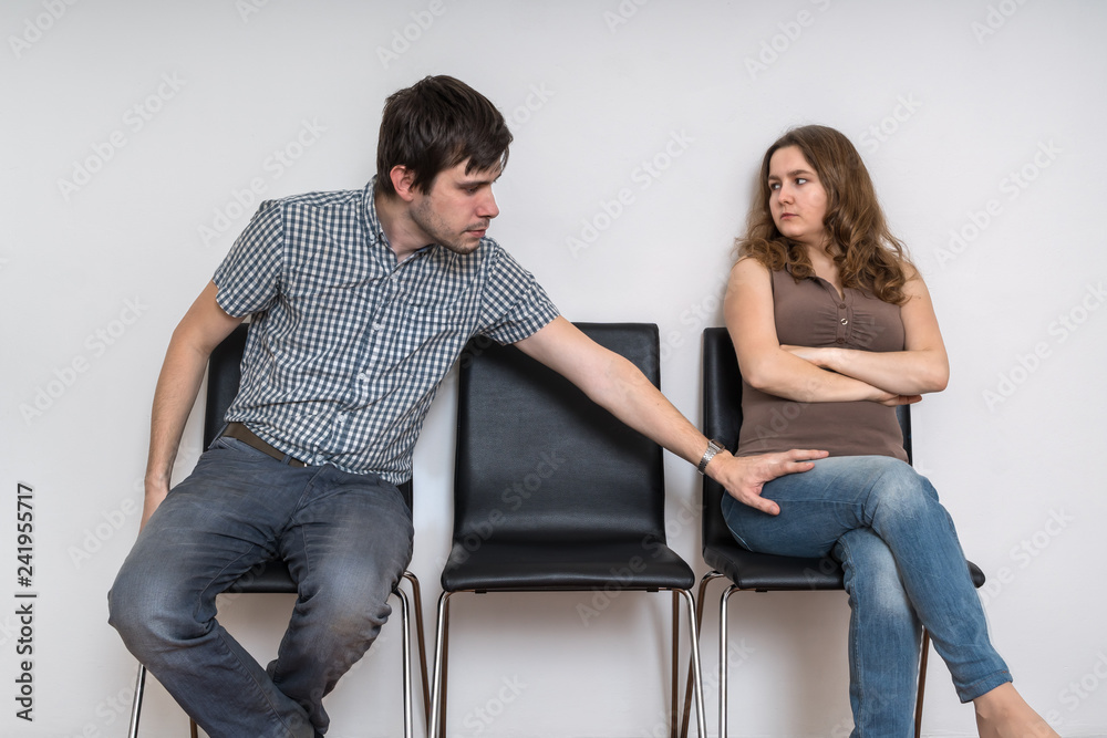 Young man is touching woman in waiting room. Sexual harassment concept ...