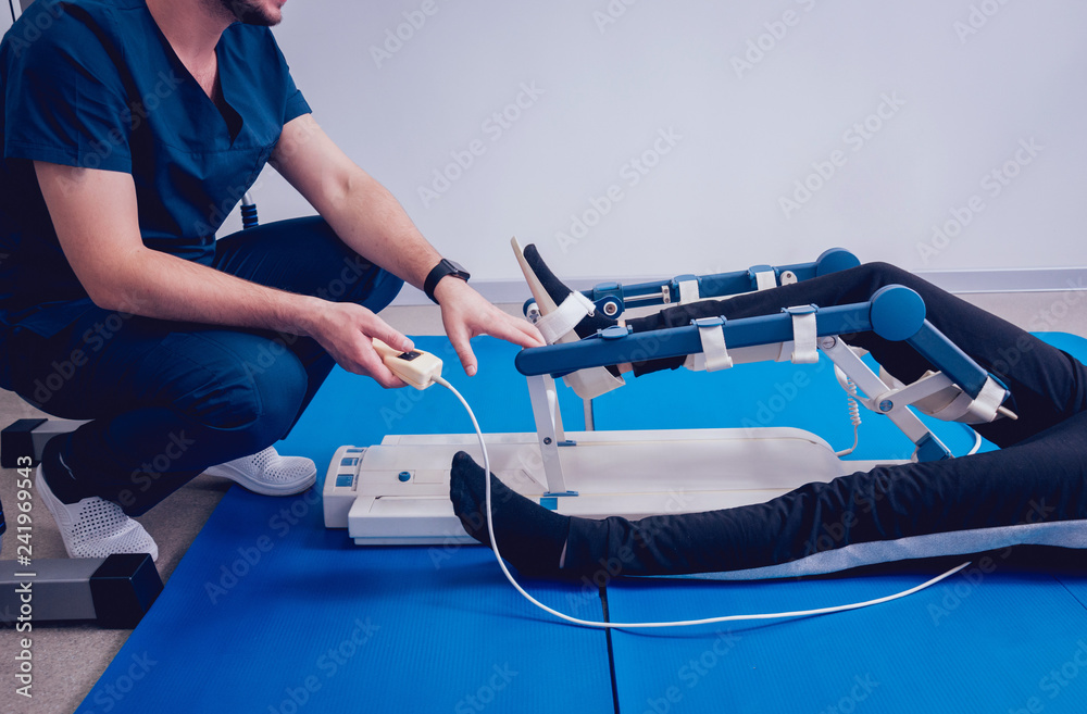 Patient on CPM (continuous passive range of motion) machines. Device to ...