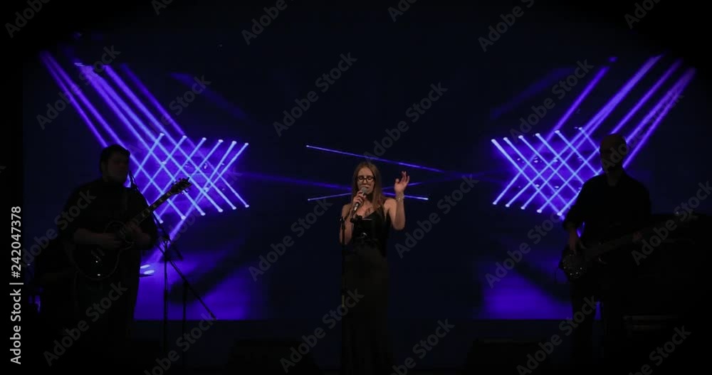 Singer woman on stage, led screen background. The rock vocalist sings a ...