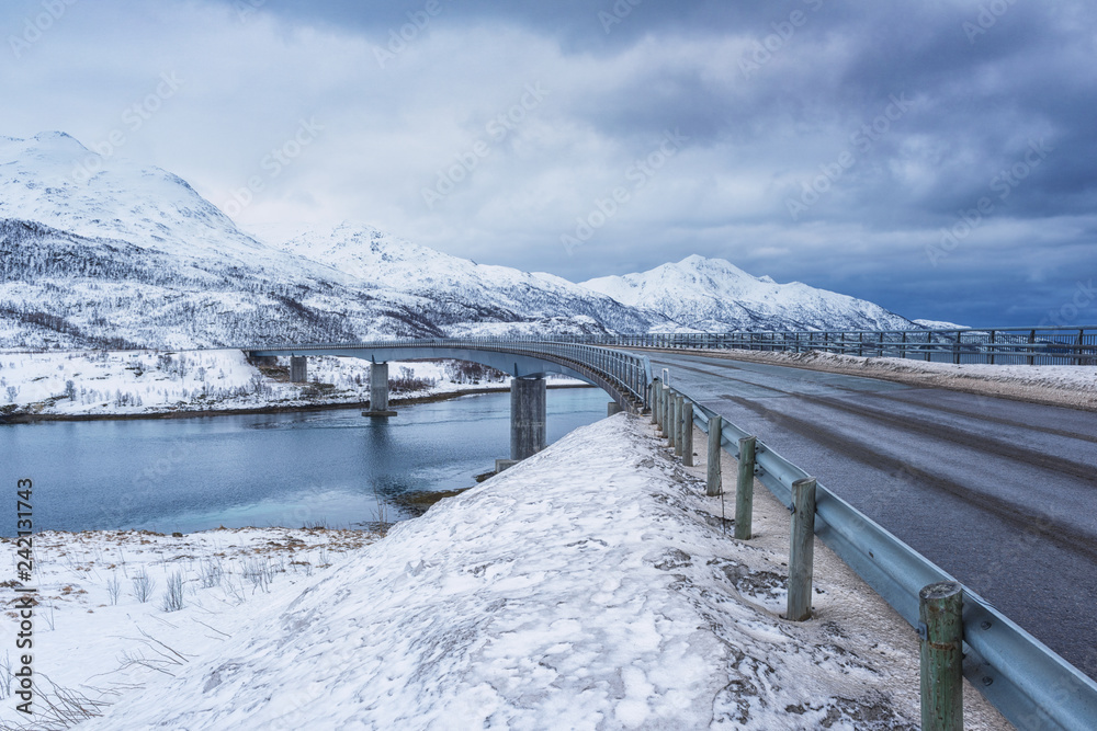 Winter daytime landscape in the Norway with road and bridge between ...