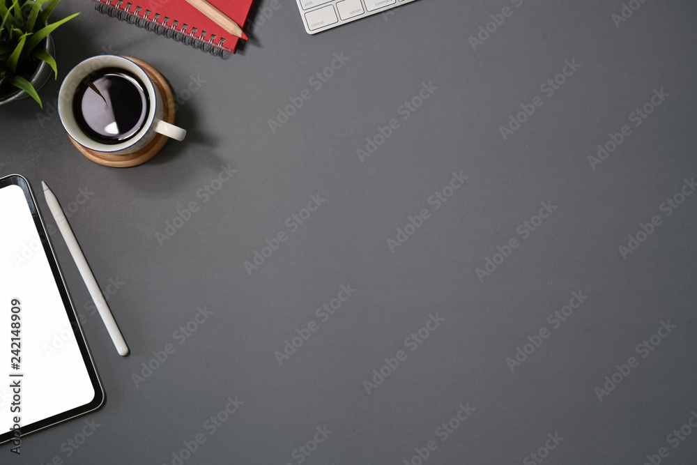 Office dark desk table with computer, supplies, tablet and coffee mug ...