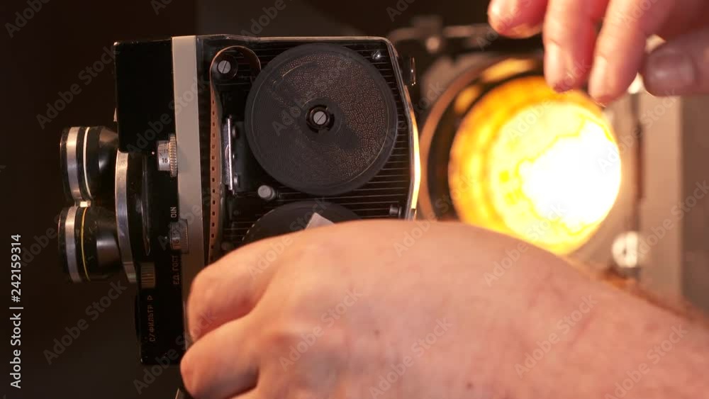 Man filming with vintage 8mm film movie camera. Loading spool of film ...