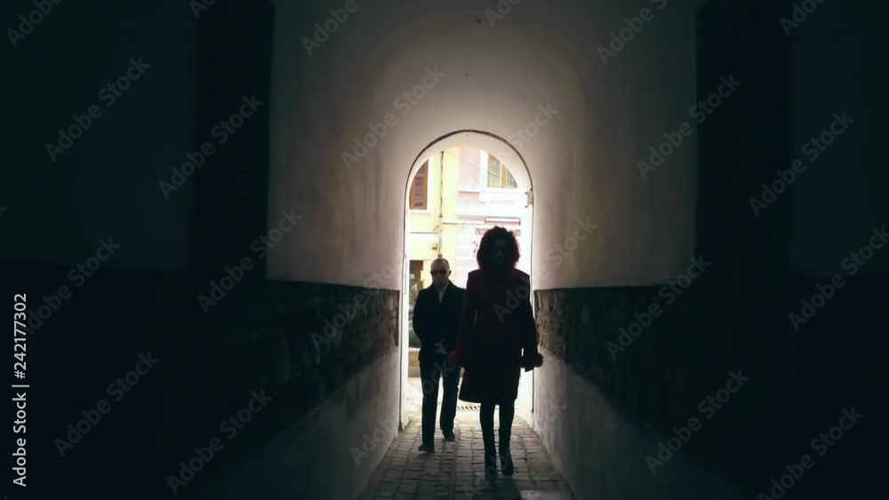 Scene of two actors entering a tunnel from the light, walking towards ...