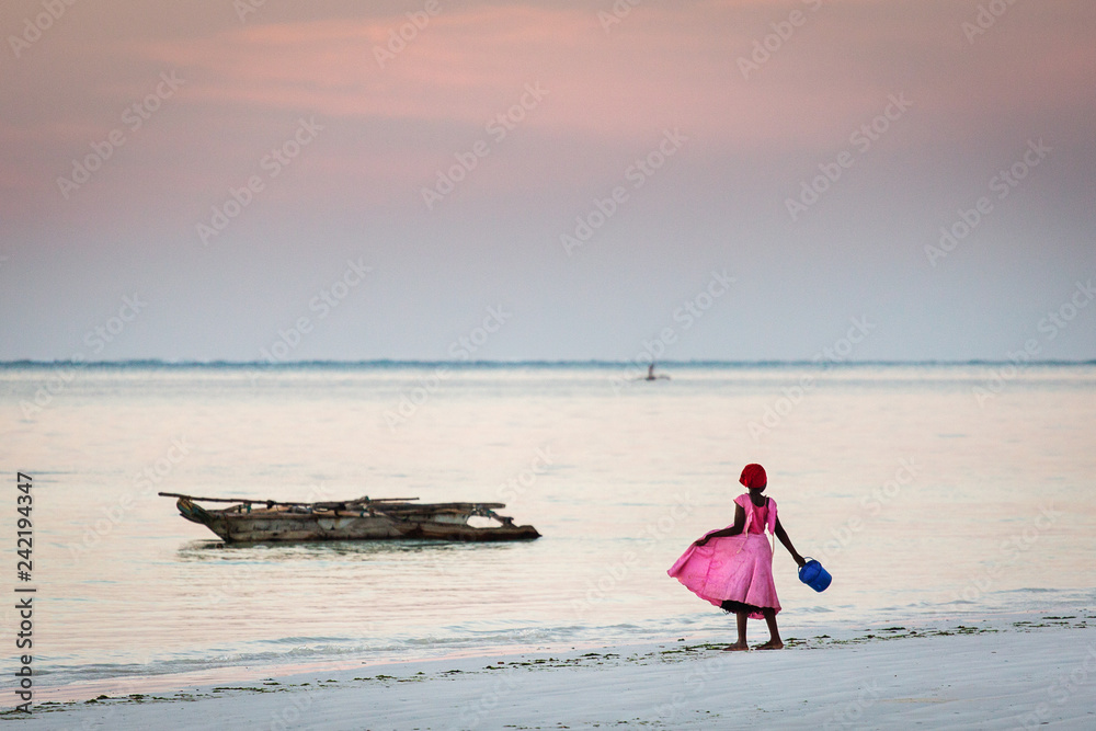 Foto de Young girl in pink playing on the beach of Zanzibar Island ...