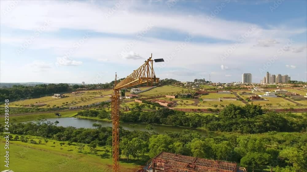 Aerial bird view of yellow tower building crane fly around construction ...