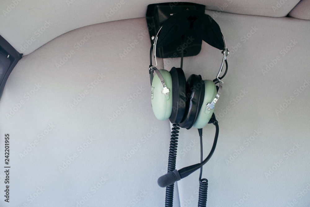 Radio headphones of the helicopters pilot mounted in cockpit cabin ...