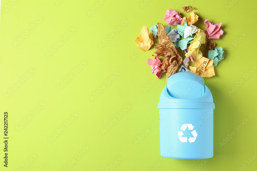 Trash bin and different garbage on color background, top view with ...