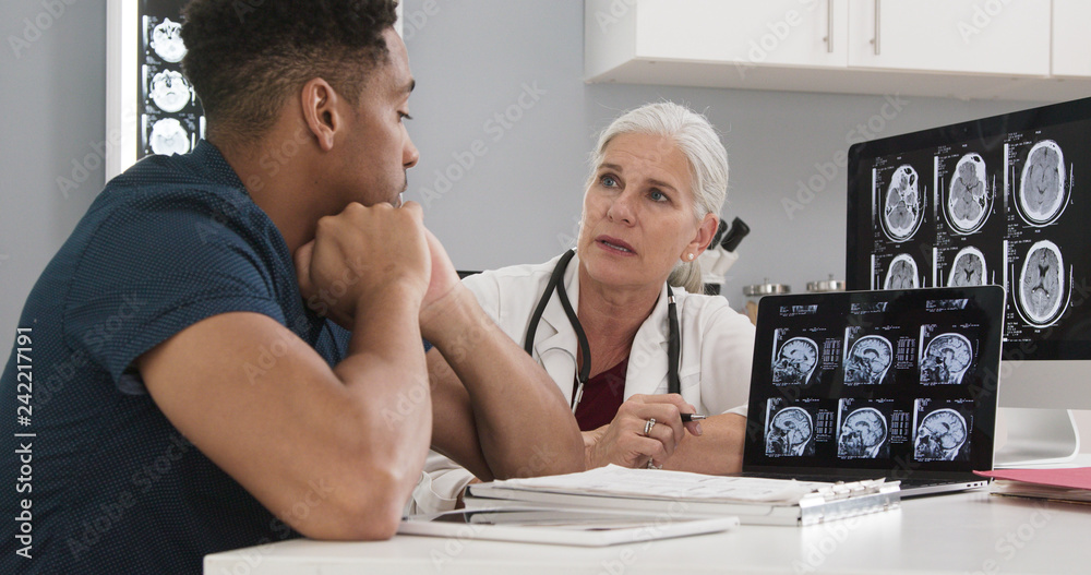 Young black male patient looks at ct scan of his cranium after ...
