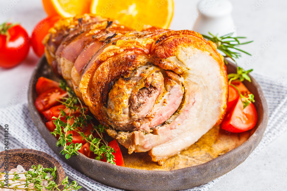 Classic Italian baked porchetta with oranges. Baked pork on white ...