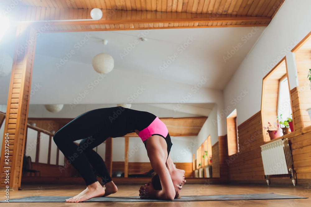 Beautiful woman practices backbend yoga asana Urdhva Dhanurasana ...