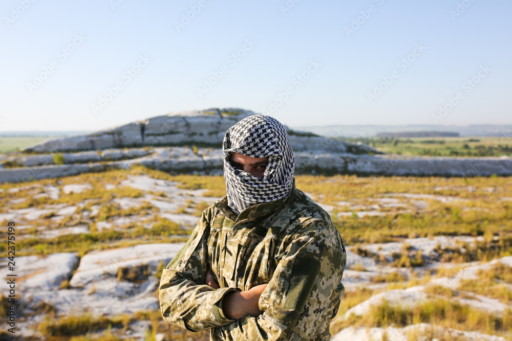 Soldier is standing in the camouflage uniform and checkered keffiyeh ...