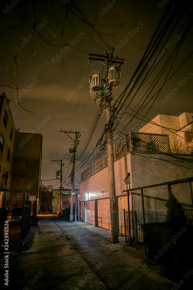 Scary urban night city alley with eerie pole-mount transformers in ...