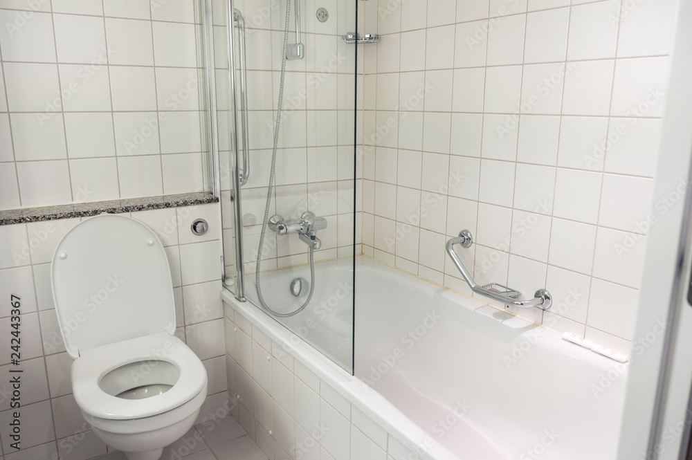 White ceramic clean lavatory with bathtub and glass partition in toilet ...