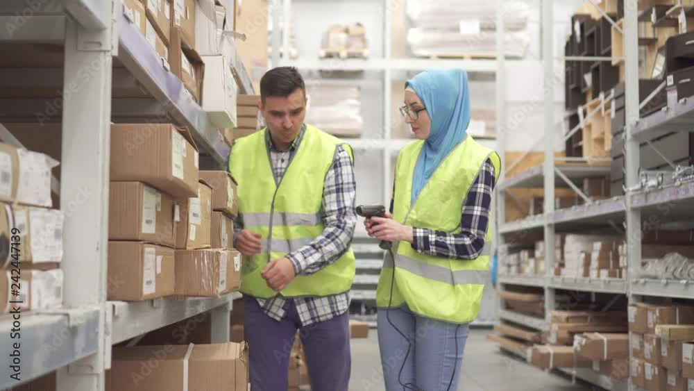 Man store worker shows a muslim woman how to use a barcode scanner Stock ビデオ | Adobe Stock