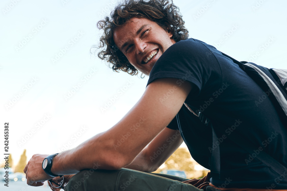 Rear view of smiling cheerful young man wears black t-shirt and ...