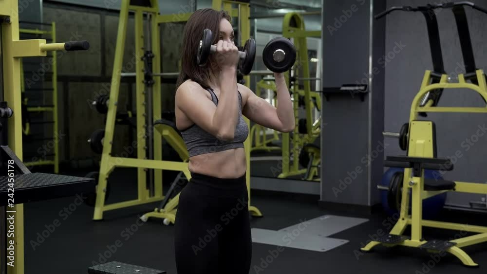 Charming Young Woman Doing Exercises For The Muscles Of The Arms With ...
