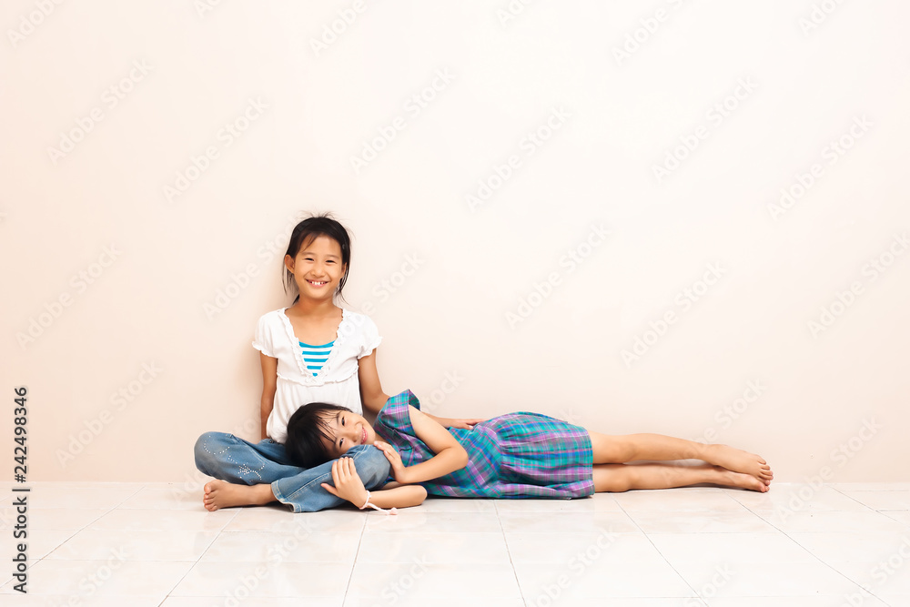 Little asian girl sitting with her old sister on floor at home. lovely ...