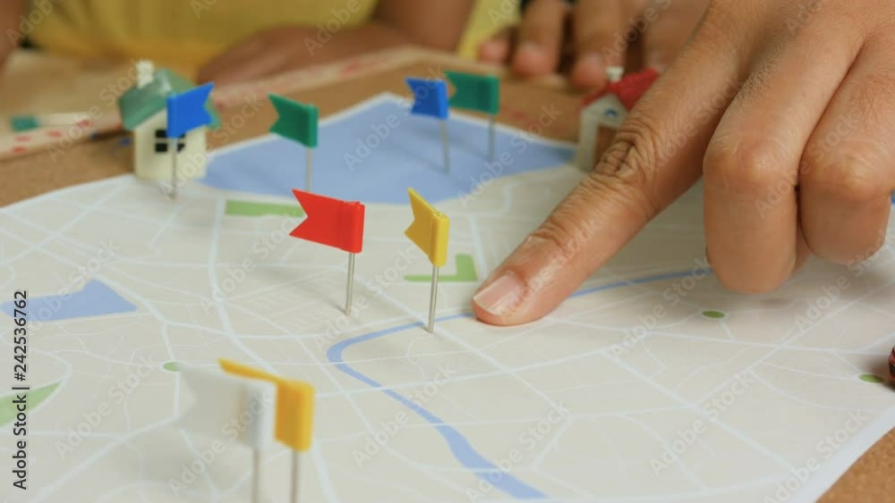 Close up shot hand of kids and mother pinning color pin at the map ...