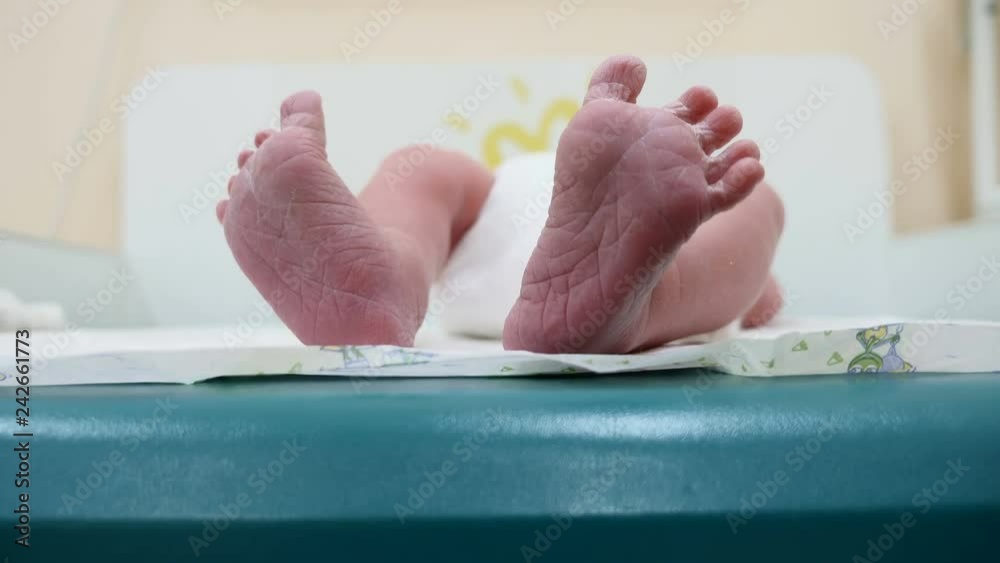 Newborn baby boy lying on back. Baby is kicking and stretching legs ...