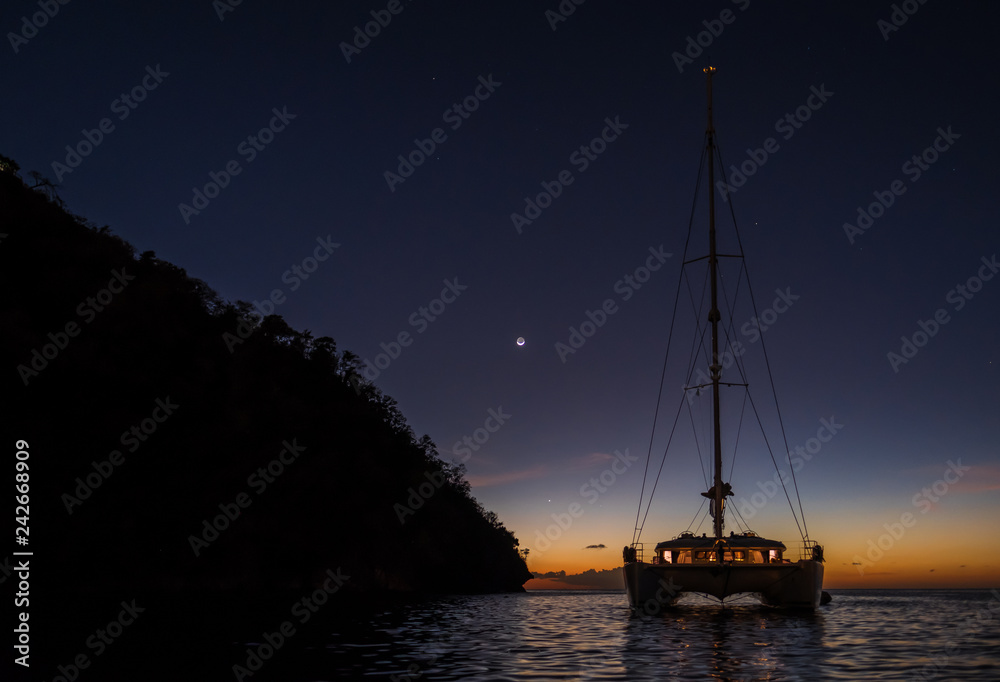Dark night view on sailing boat anchored on open sea with black ...