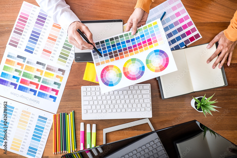 Two colleague creative graphic designer working on color selection and ...