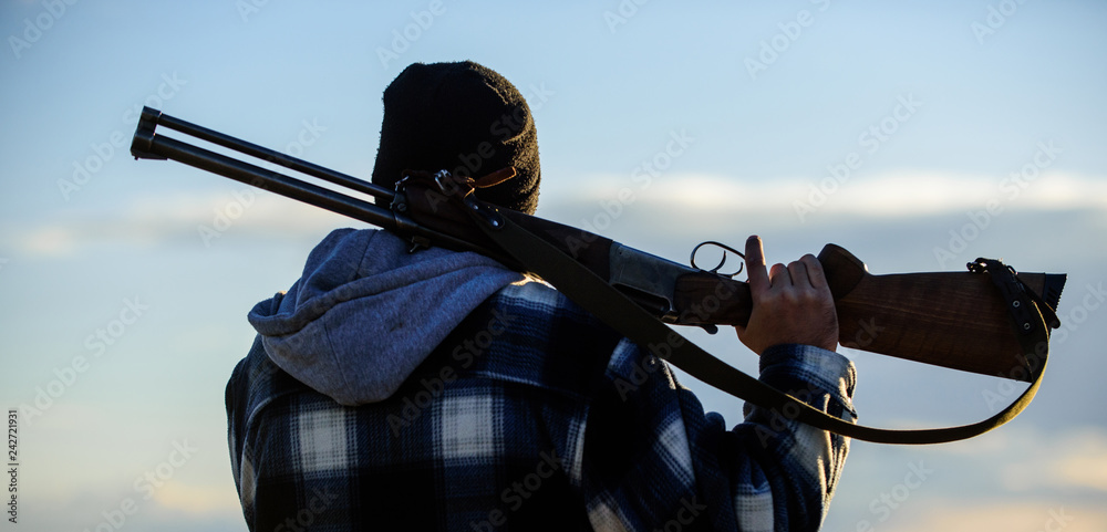 Brutality and masculinity. Hunter carry rifle gun on shoulder rear view ...