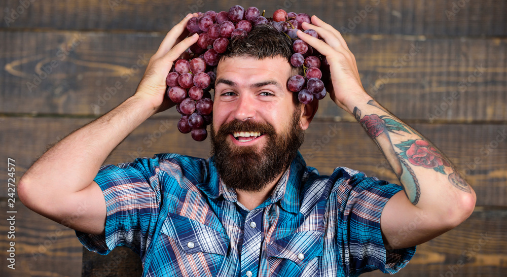 Farmer proud of grapes harvest. Man hold grapes wooden background ...