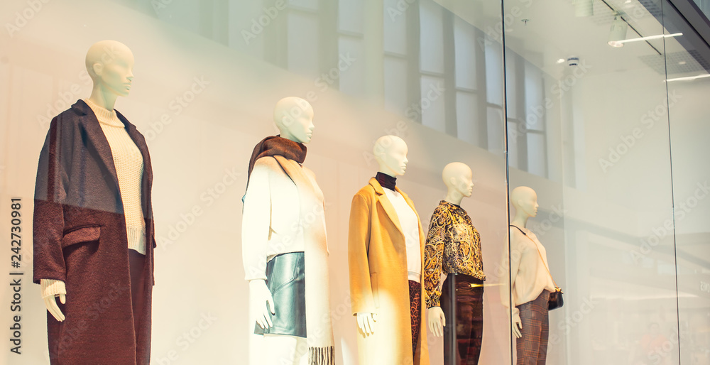 Mannequins in fashion shop display window inside of mall. Female casual ...