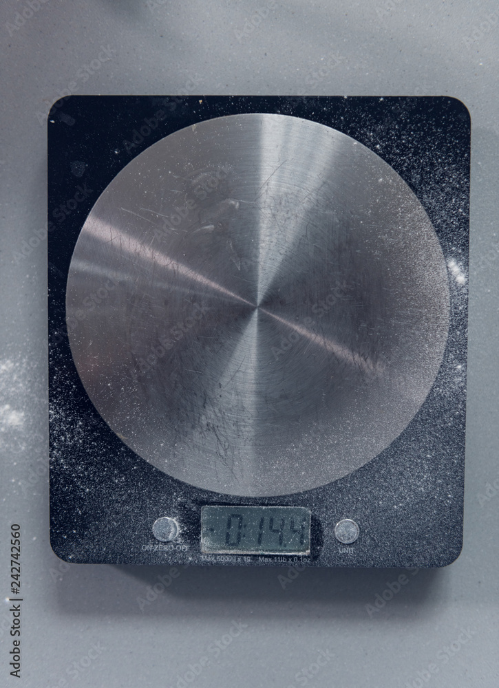 A used digital weighing scale shot from above in a grey and silver ...