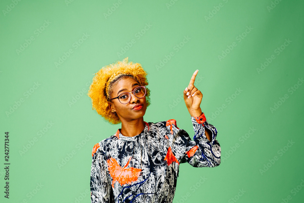 Young woman pointing up, isolated on green studio background. Stock ...