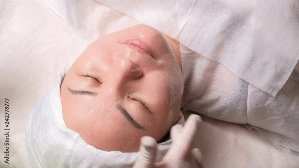 The hands of a beautician or a plastic surgeon in white gloves put the ...