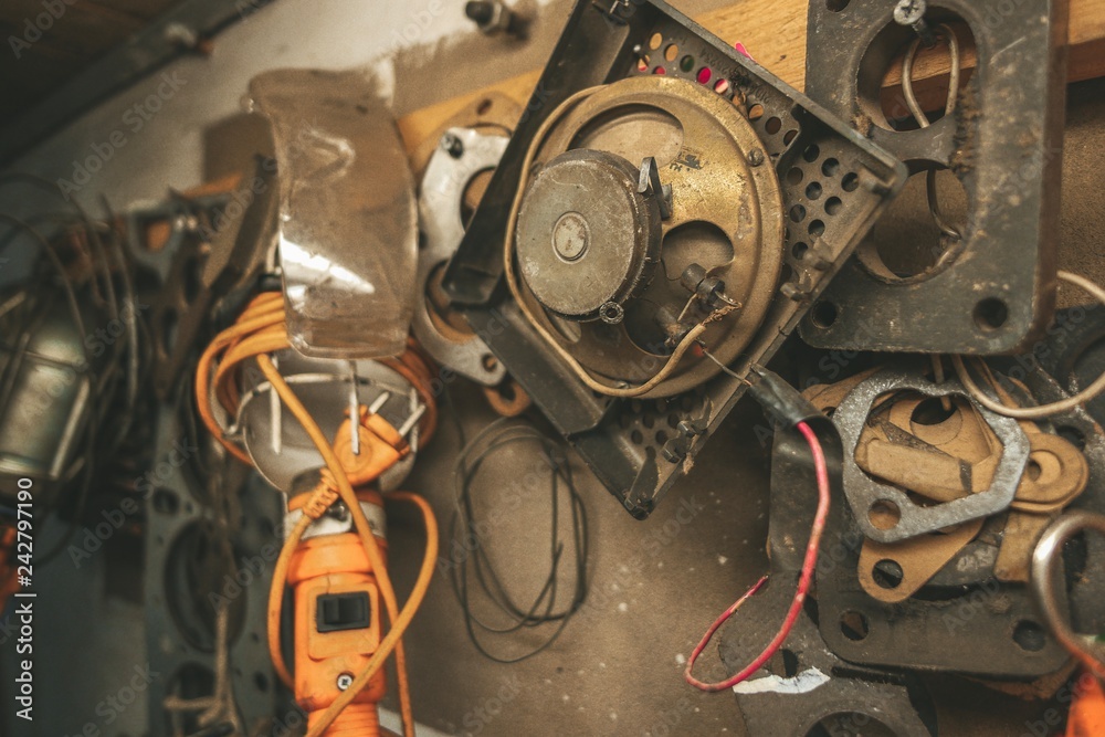Dirty gloomy messy garage, where parts, construction tools lying around ...