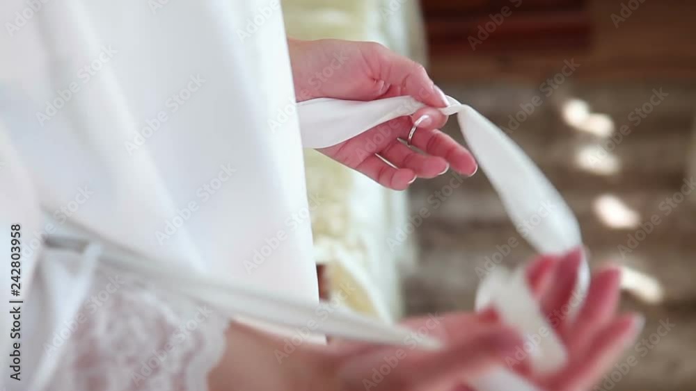 The bride takes off a white silk robe. The girl drops her robe from her ...