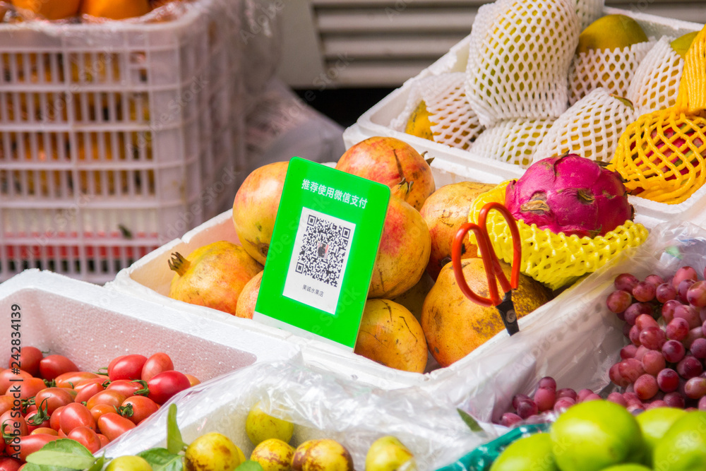 Qr codes for cashless payment with smart phones stands over a vegetable ...