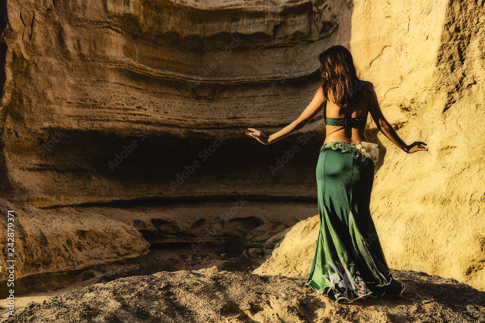 Foto de Young girl in green dress dancing the famous belly dance, in ...