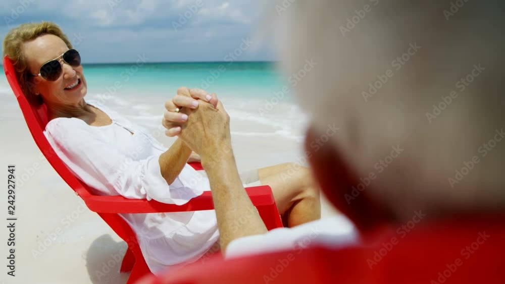 Retired couple in red chairs on beach Bahamas Stock Video | Adobe Stock