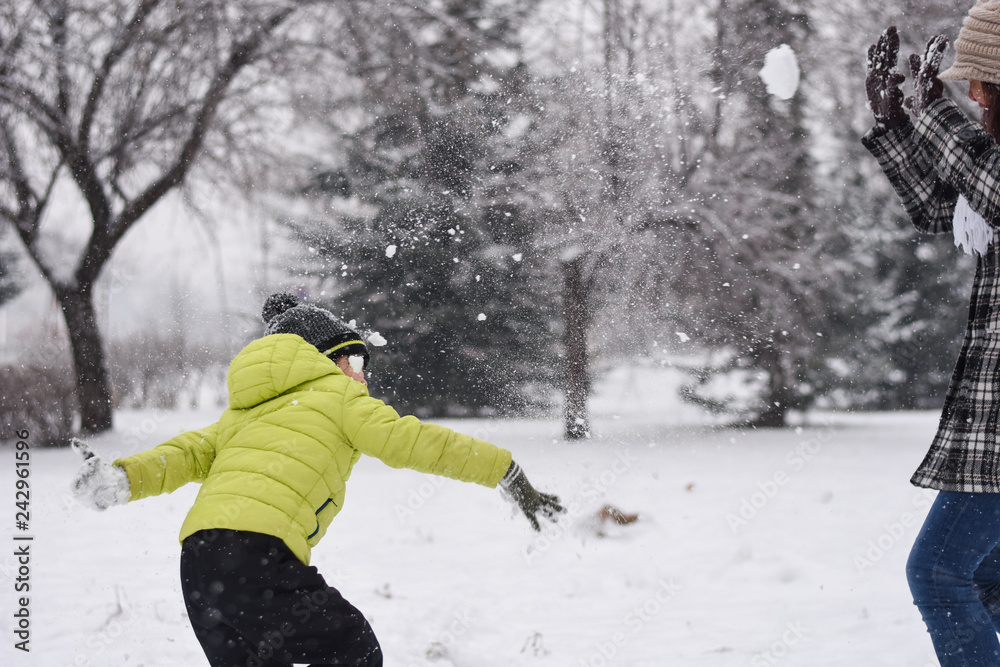 Mom and son playing snowball fight and smiling in winter. Happy family ...