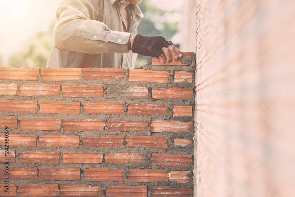 Worker installing bricks wall in process of house building Stock Photo ...
