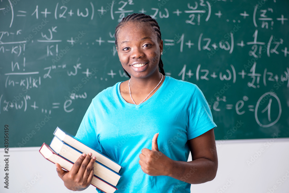 Black female student in front of chalkboard Stock Photo | Adobe Stock