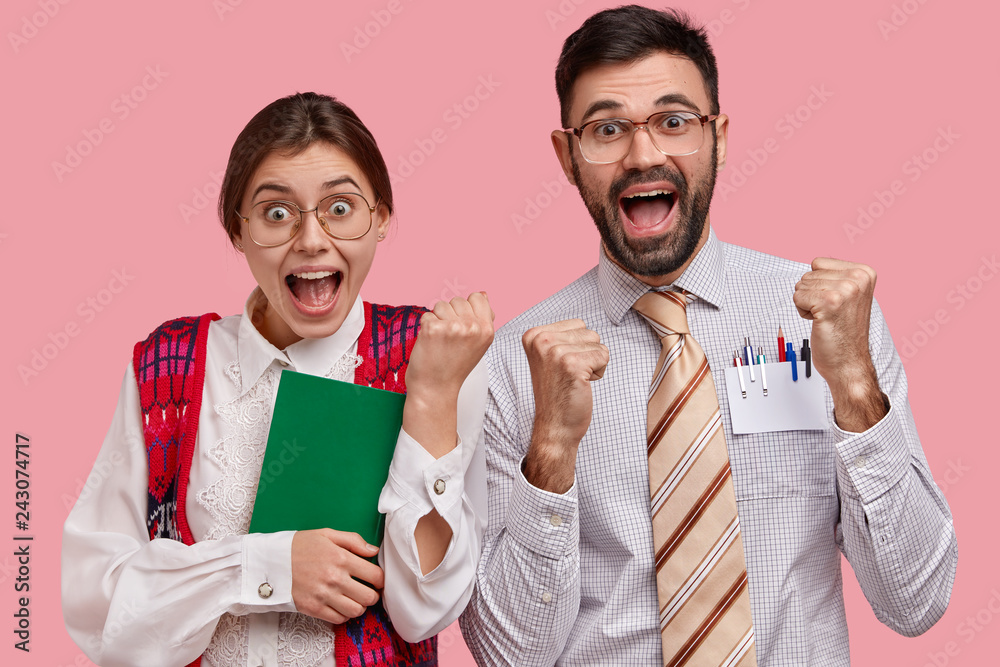 Overjoyed clumsy woman and man nerds clench fists, celebrate finishing ...