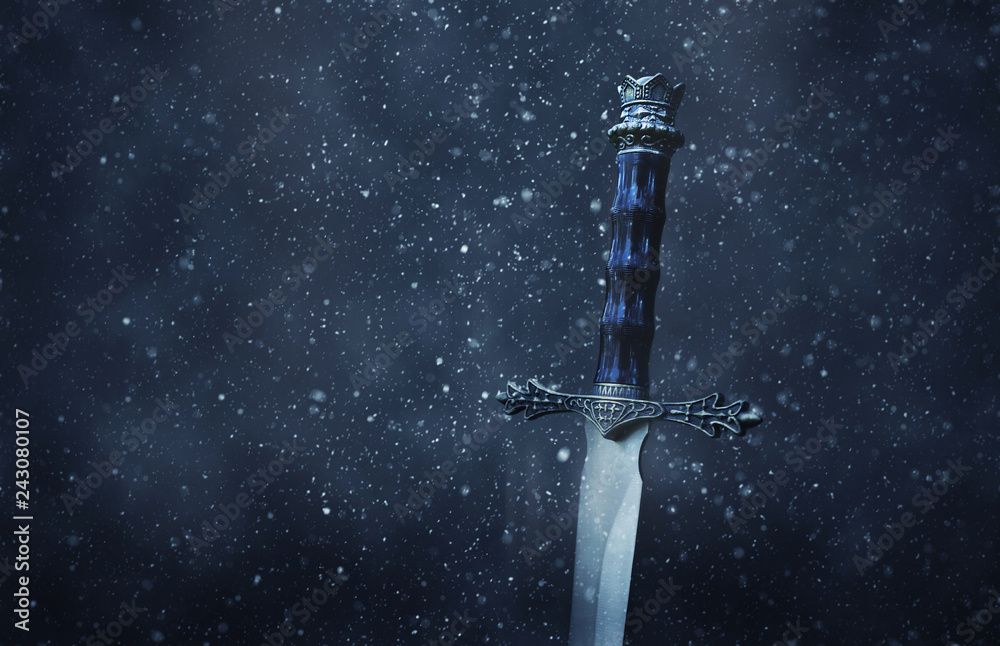 mysterious and magical photo of silver sword over gothic snowy black ...