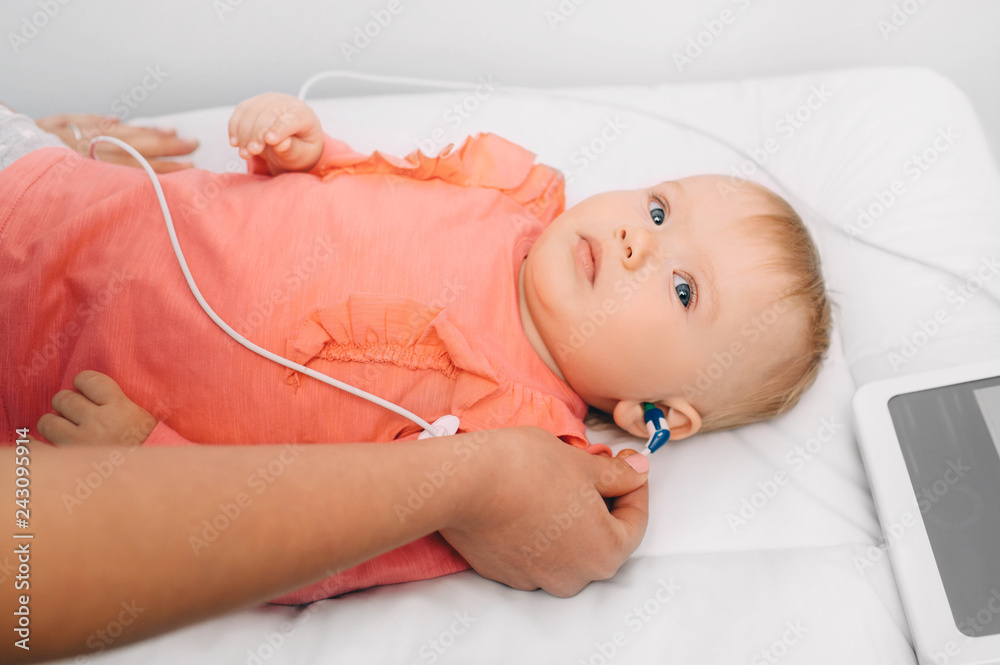 doctor check a baby girl's ears. Little baby having hearing test ...
