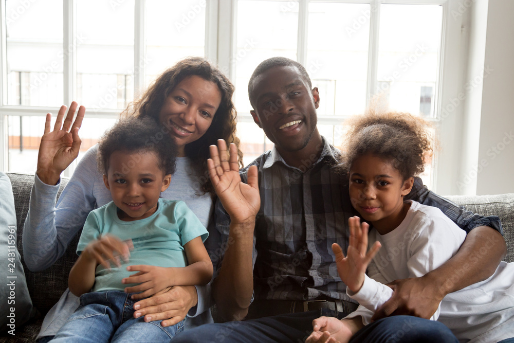 Happy african american family with 2 kids son daughter waving hands looking at camera, portrait ...