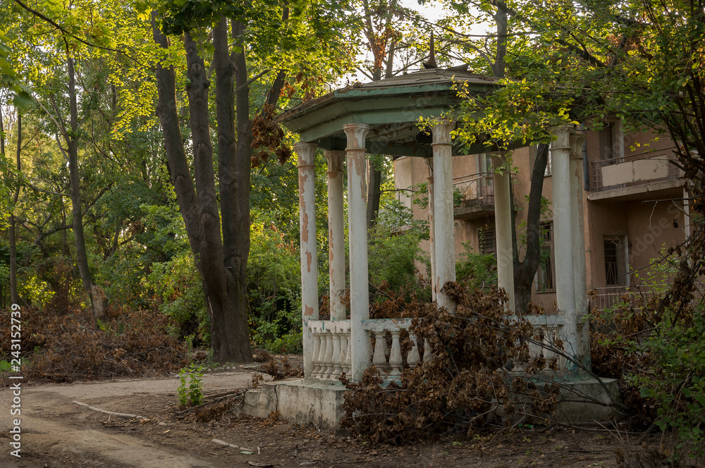 Old destroyed stone house on the yard with trees around. Poverty and ...