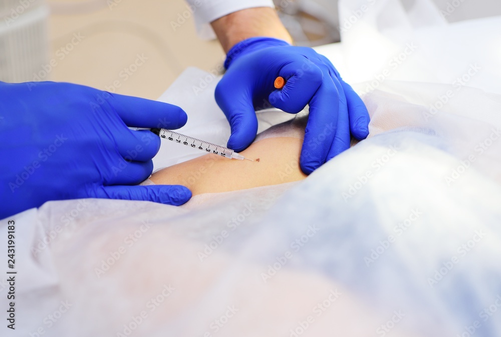 Foto de the surgeon makes an anesthesia injection to the patient of the ...