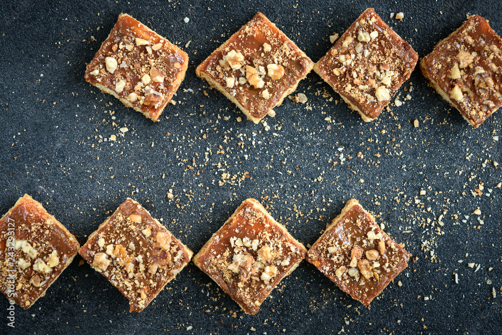 Homemade caramel shortbread squares cookies with nuts laid in the shape ...