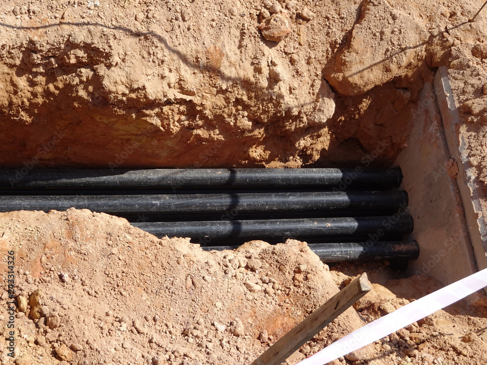 Underground utility and services pipe laid by workers in the trenches ...